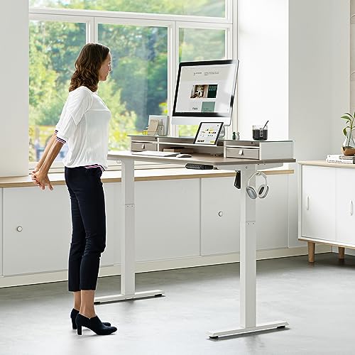 FEZIBO Electric Standing Desk with Double Drawers, 55 x 24 Inch Glass Top Monitor Stand Adjustable Sit Stand Desk with Storage Shelf, White Frame/LightWalnut Top