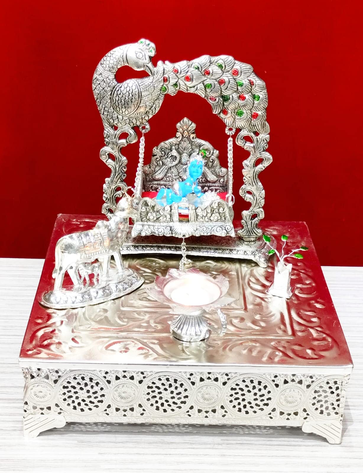 Crafting with Love a Beautiful Little Krishna Peacock jhula with German Silver chowki + Cow Calf + tulsi Plant + Lotus Handle Diya