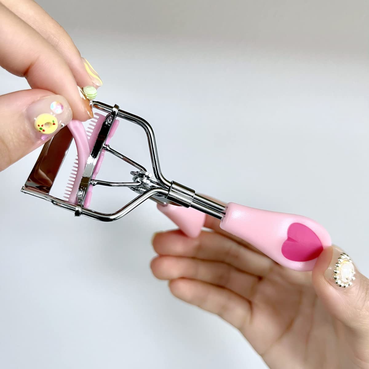 MERVK Stainless Steel Eyelash Curler with Built-in Comb Pinch Pain-Free Suitable for Any Eye Shapes and Sizes, with 5 Silicone Refill Pads (Light Pink)
