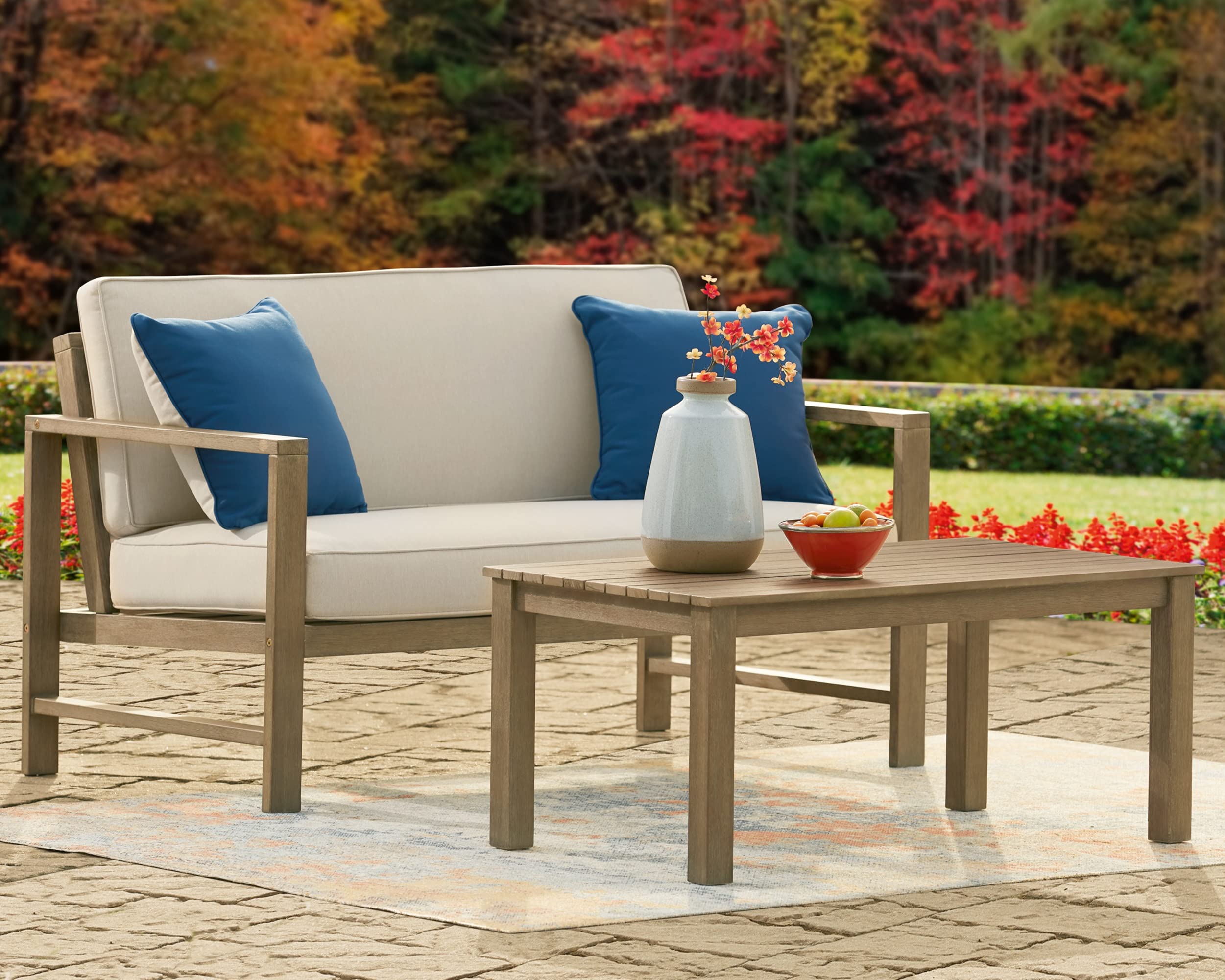 Signature Design by Ashley Outdoor Fynnegan Patio Eucalyptus Loveseat & Coffee Table, Beige with Blue Pillows