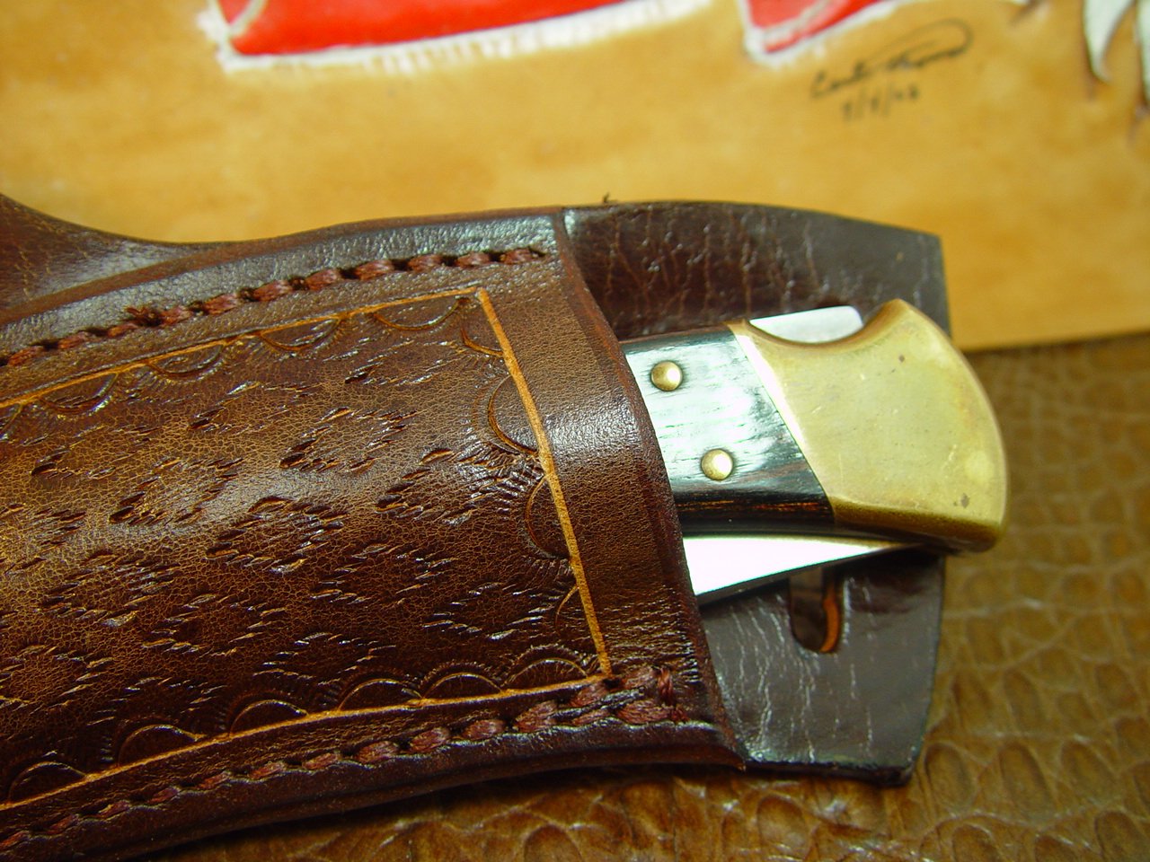 Custom left hand cross draw knife sheath for a buck 110 knife. The sheath is made out of buffalo hide leather hand tooled with a basket weave pattern.