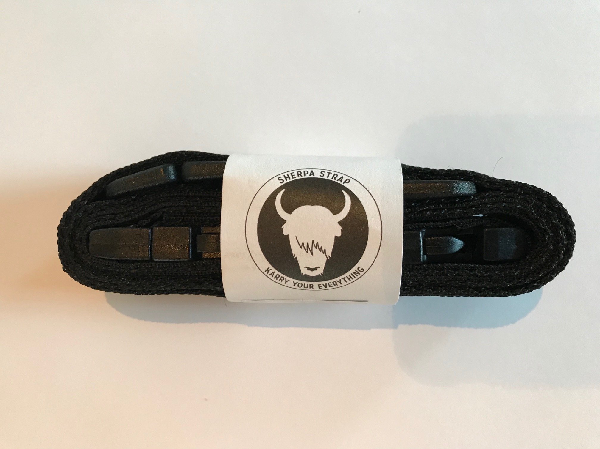 Carrier strap for single or multiple pairs of skis, poles, boots or snowboards