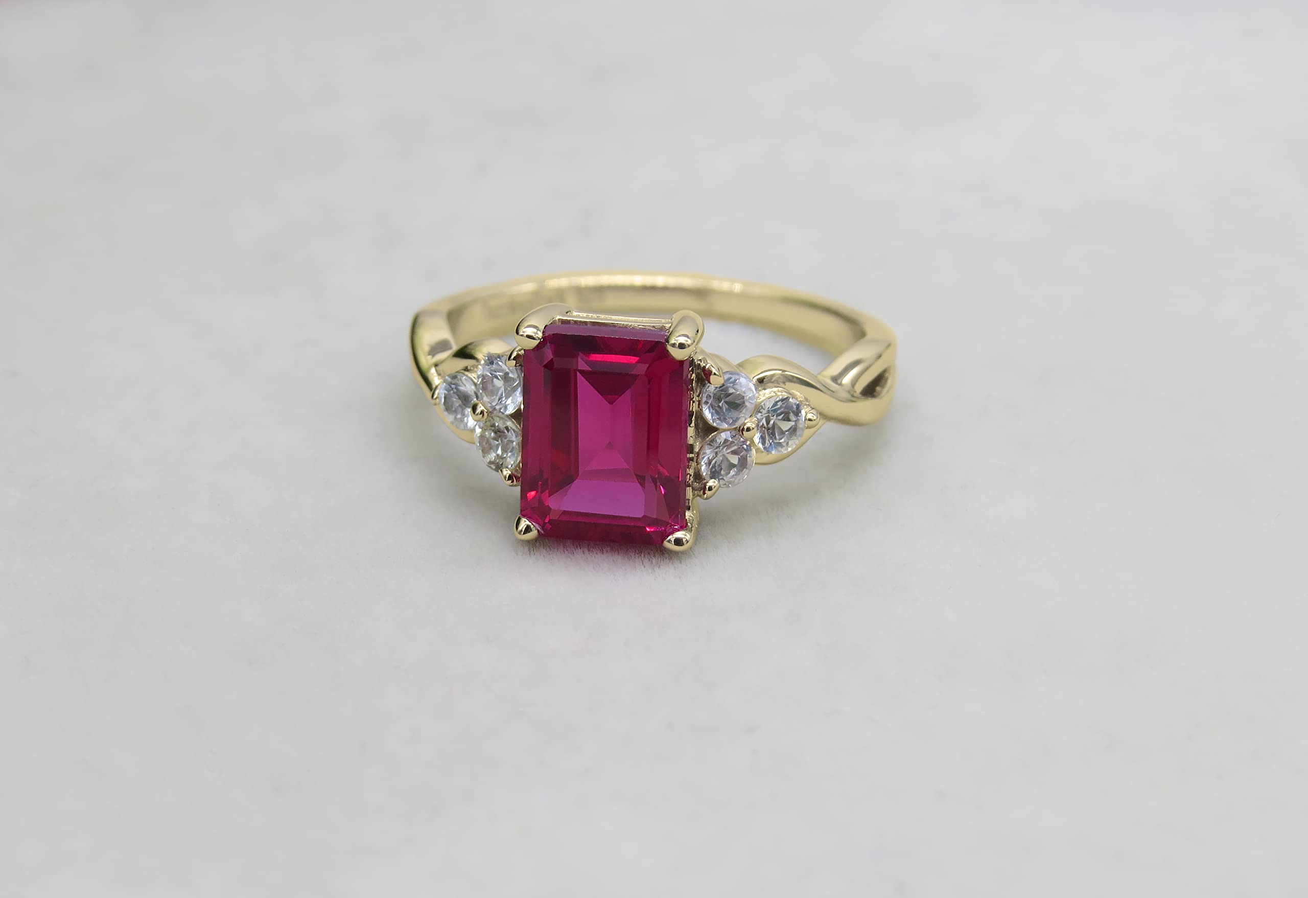 Dazzlingrock Collection 8x6mm Emerald Shape Center Lab Created Ruby & 2.2mm Round White Sapphire on Side Crisscross Shank Engagement Ring for Her in 10K Yellow Gold Size 7