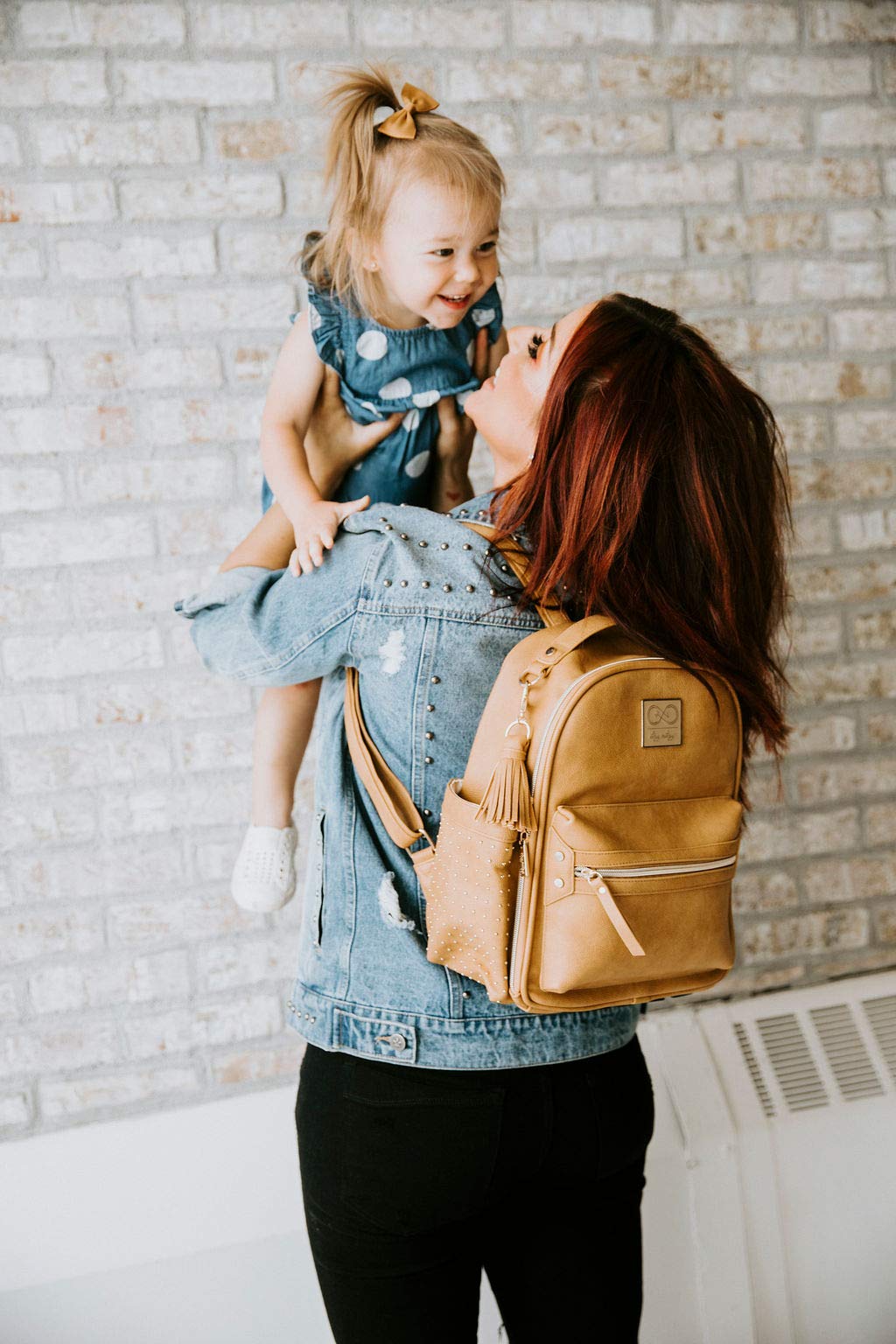 Itzy Ritzy Chelsea + Cole Mini Diaper Bag Backpack - Studded Mini Backpack with Changing Pad, 8 Pockets, Rubber Feet & Tassel - Caramel with Sweetheart Print Interior and Gold Hardware